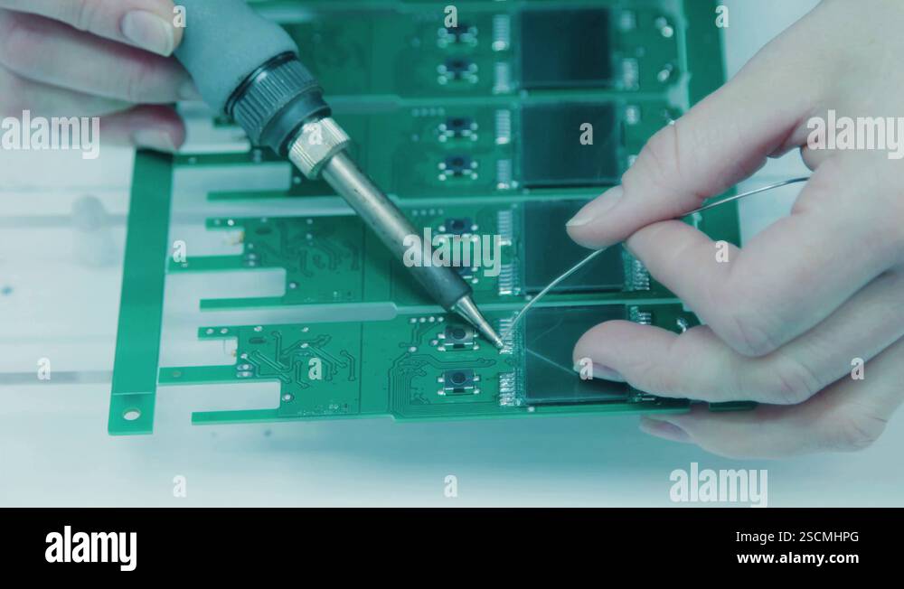 Industrial setup. Factory worker soldering components on a printed ...