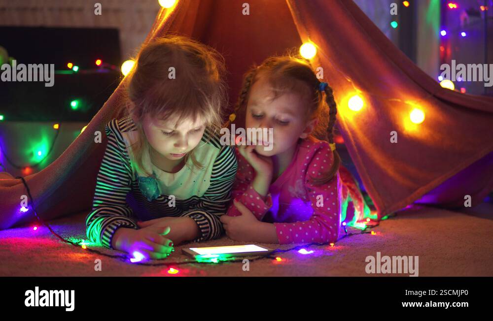 Children play on the smartphone in the evening at home. Dolly shot ...