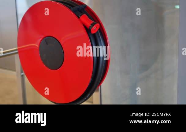 A red fire hose reel is mounted to the wall for immediate emergency use ...