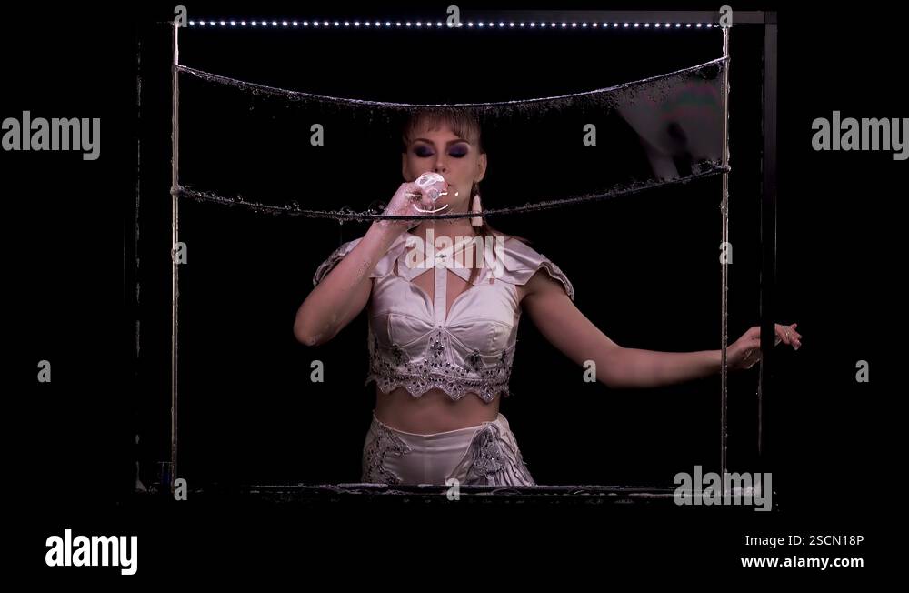Pretty girl does tricks with soap bubbles. She blows a few bubbles in ...
