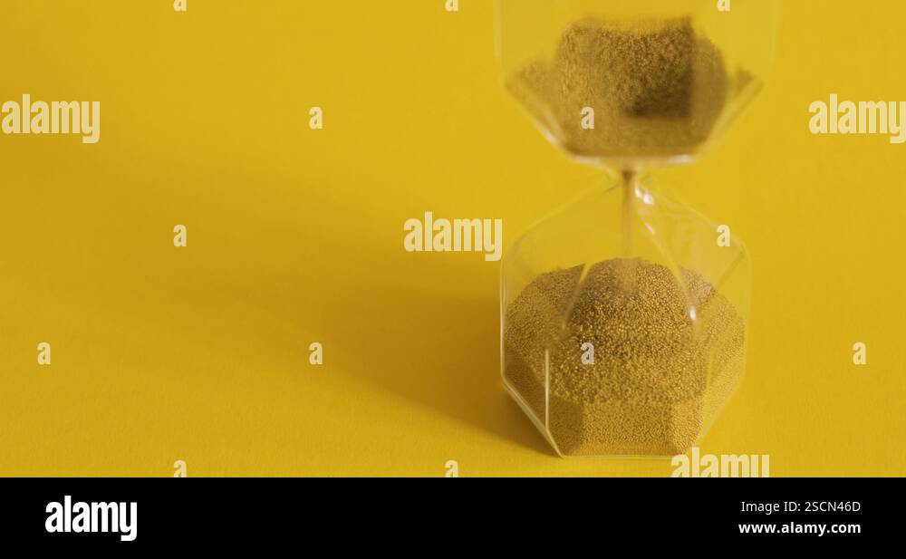 Hourglass on yellow background. Time is up. Time and transience concept ...