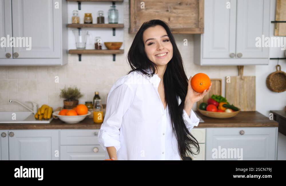 Young Woman Dancing with Orange In The Kitchen. Diet And Healthy Eating ...