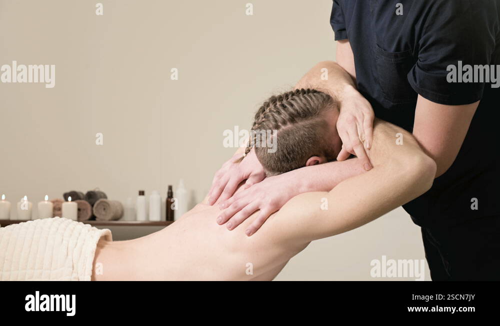 A male physiotherapist does a power stretching for a male patient to a ...