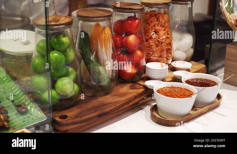 Tomatoes, limes, cucumber, corns and snacks in glass tins in Bangkok ...
