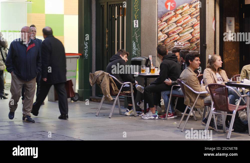 Madrid people tourists at cozy restaurant or cafe street tables sit ...