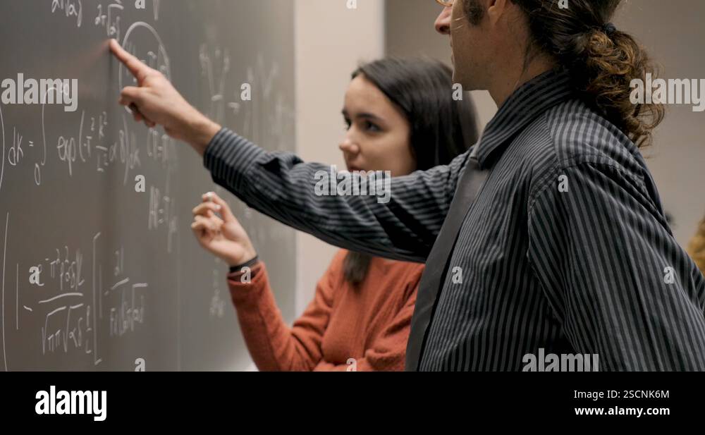Professor teaching a young female student a complicated science lesson ...