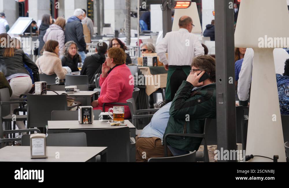 MADRID SPAIN Street cafe tables many people friends sit smoke cigarette ...