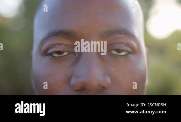Close-up of man's face, focusing on eyes and facial expression outdoors ...