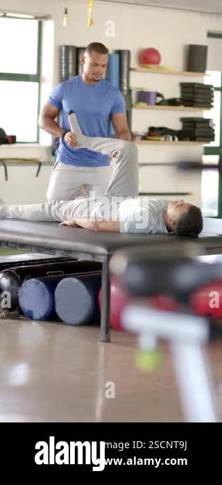 Vertical video: Physical therapist stretching patient's leg during ...