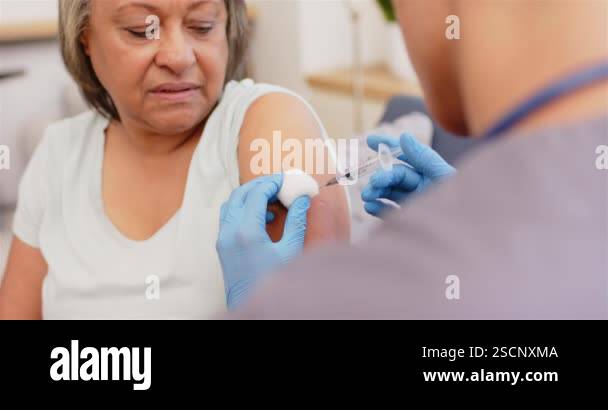 Administering vaccine, healthcare worker giving injection to senior ...