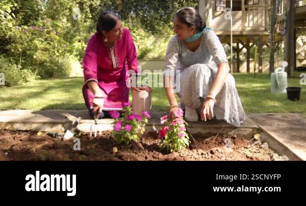 Gardening together, indian mother and daughter planting flowers and ...