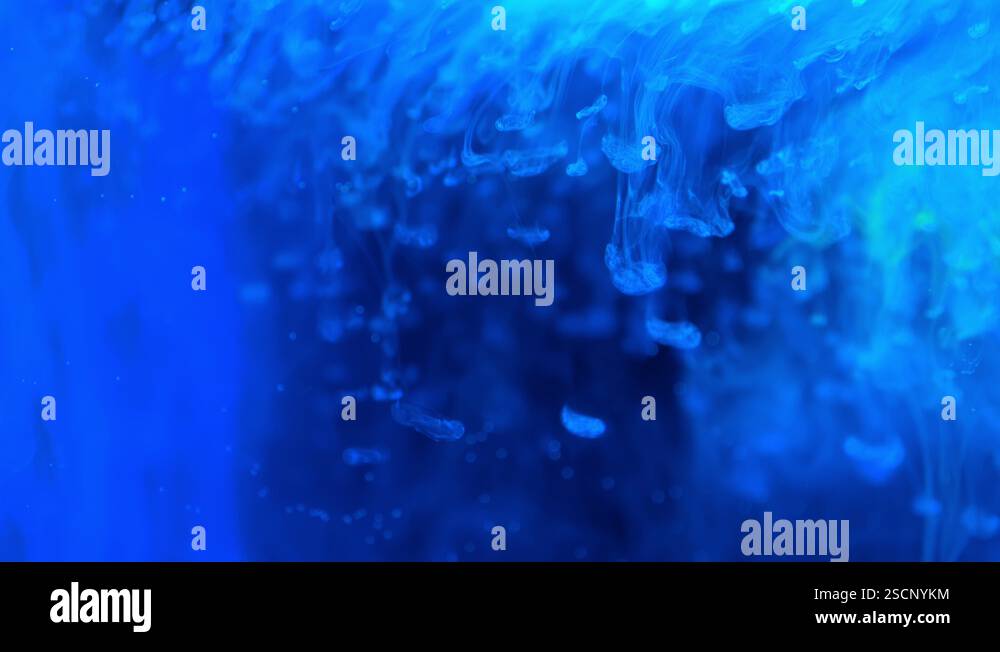 Blue color paint ink pouring over the glass in slow motion on with inky ...