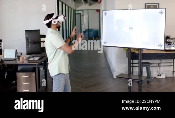 Using VR headset, man interacting with virtual screen in modern office ...