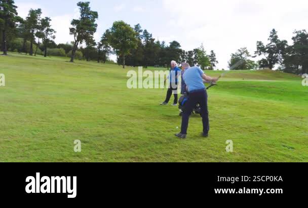 Golf players playing golf and knocking golf ball out on golf course on ...