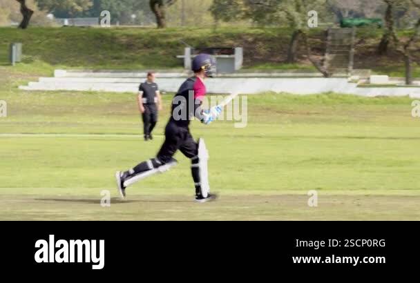 Two teams of multiracial male cricket players playing cricket, batter ...
