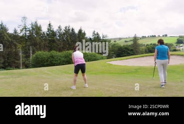 Female golf players playing golf and knocking golf ball out on golf ...