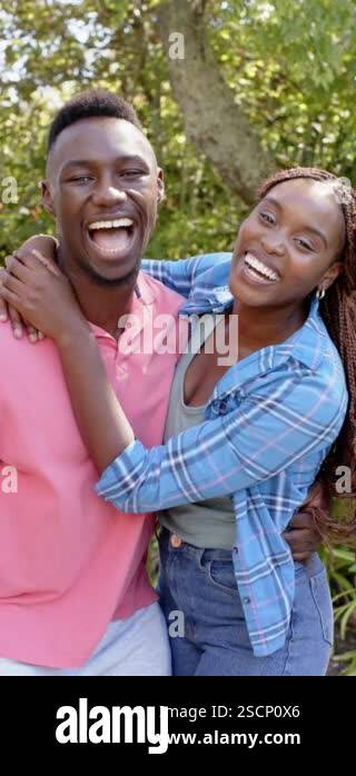 Vertical video: Smiling couple embracing outdoors, enjoying quality ...