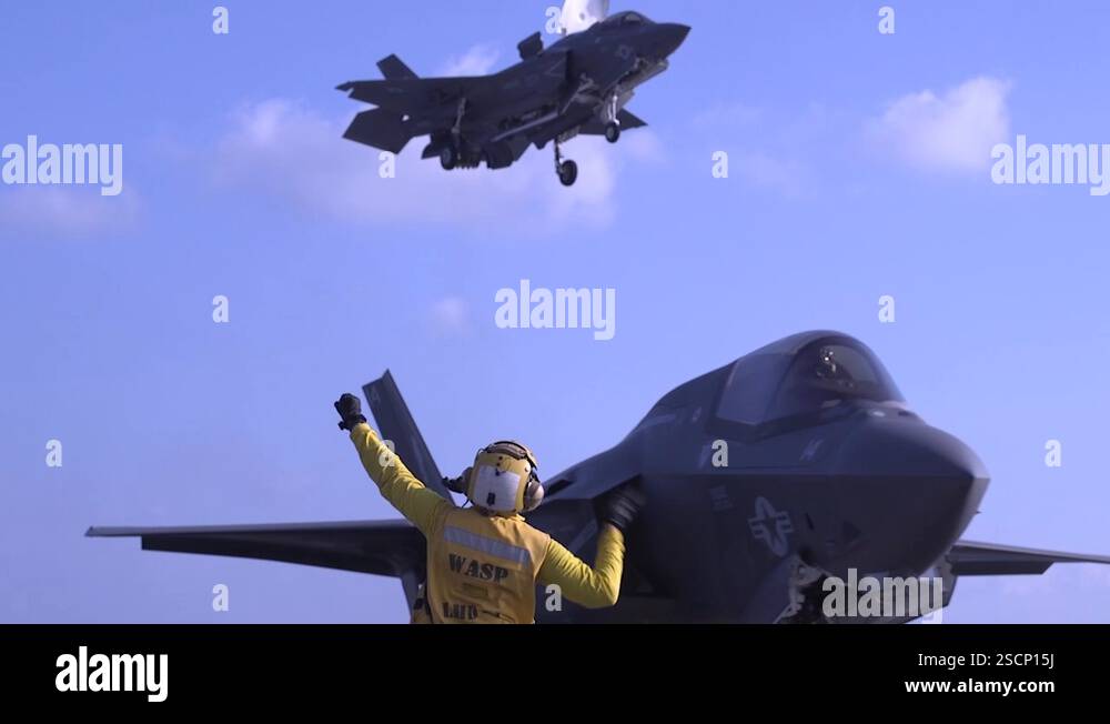 F-35B hovering while aircraft handler directs F-35B Lightning II ...