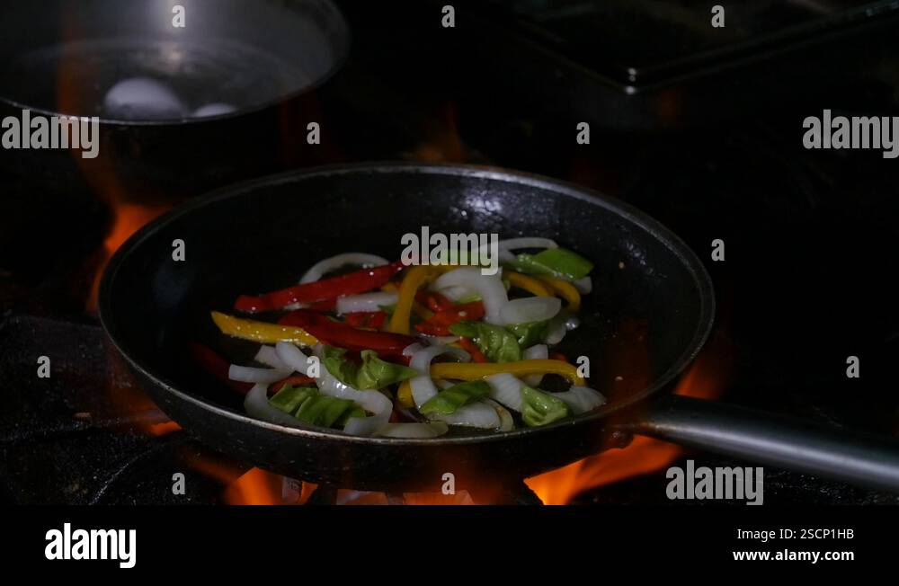 Professional chef and fire. Cooking vegetables and food over an open ...
