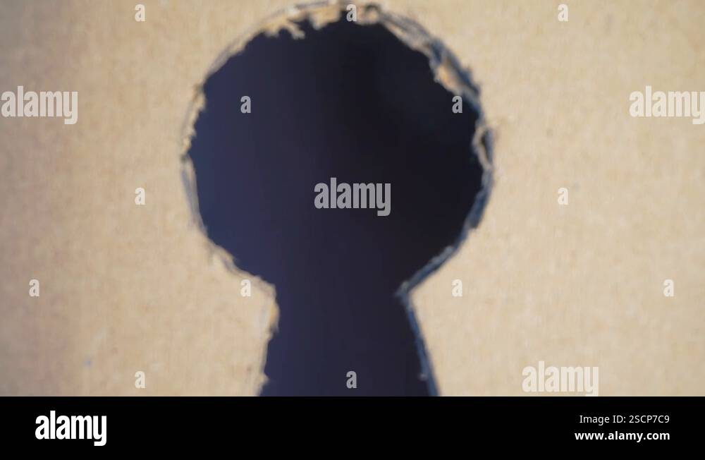 curious human eye looks into the hole in the form of a keyhole Stock Video Footage - Alamy