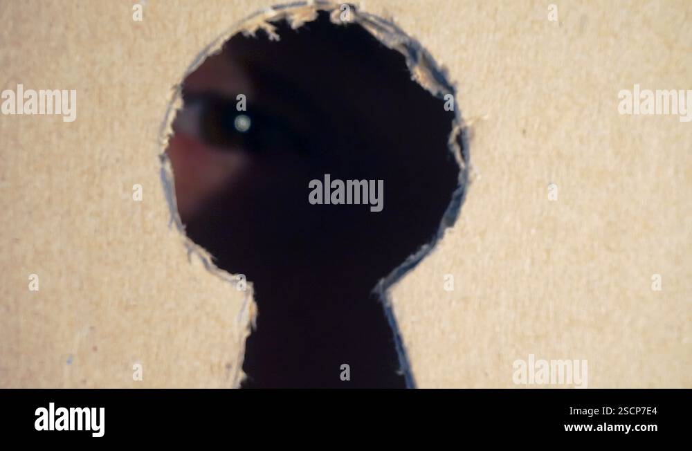 curious human eye looks into the hole in the form of a keyhole Stock Video Footage - Alamy