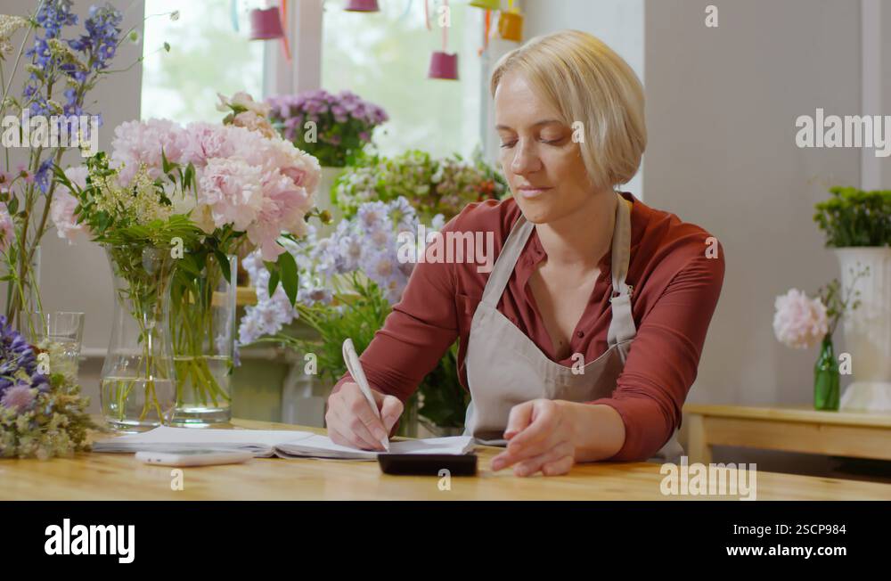 Flower shop manager doing accounting Stock Video Footage - Alamy