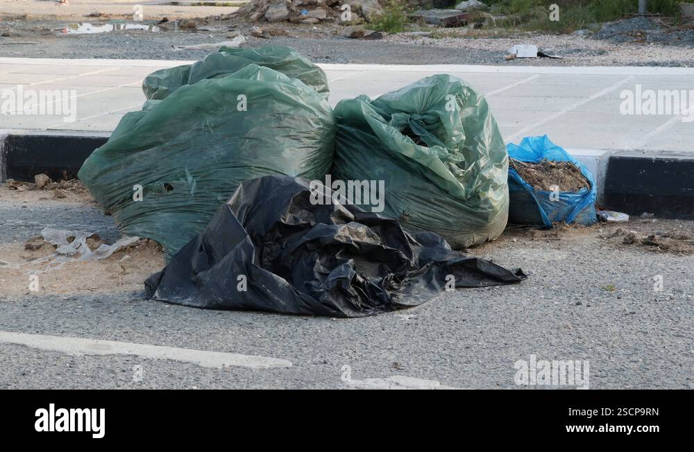 Full plastic trash bags on the street. Waste and recycle concept. Slow ...