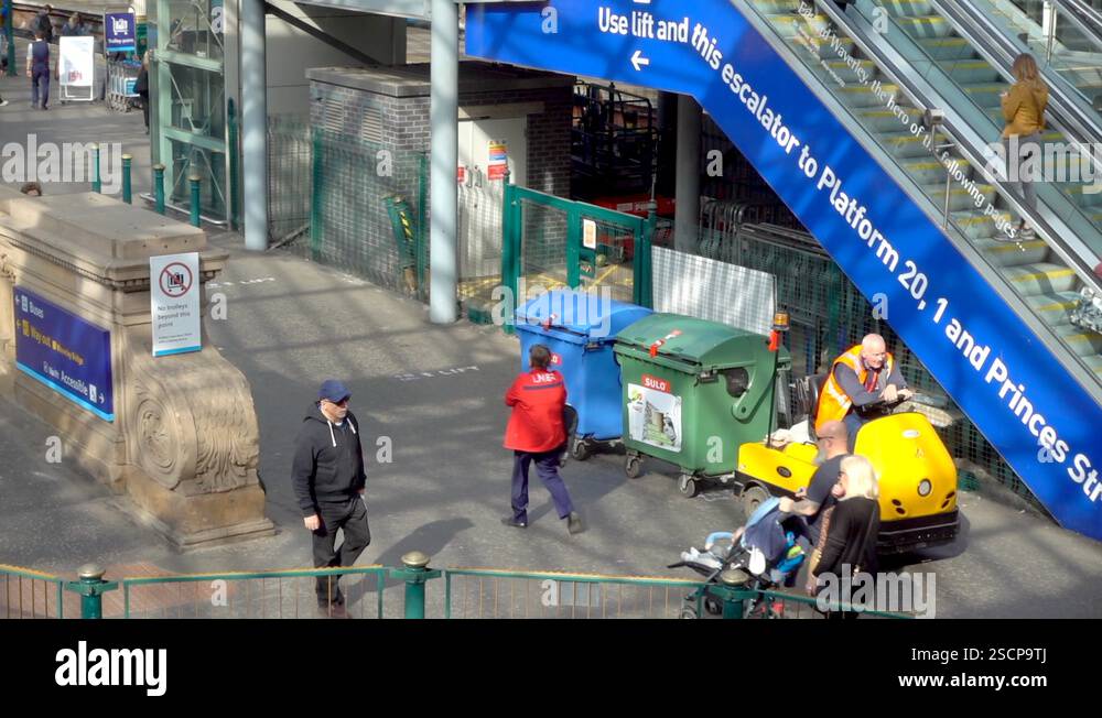Slow motion – Man driving electric vehicle pulling wheelie bins past ...
