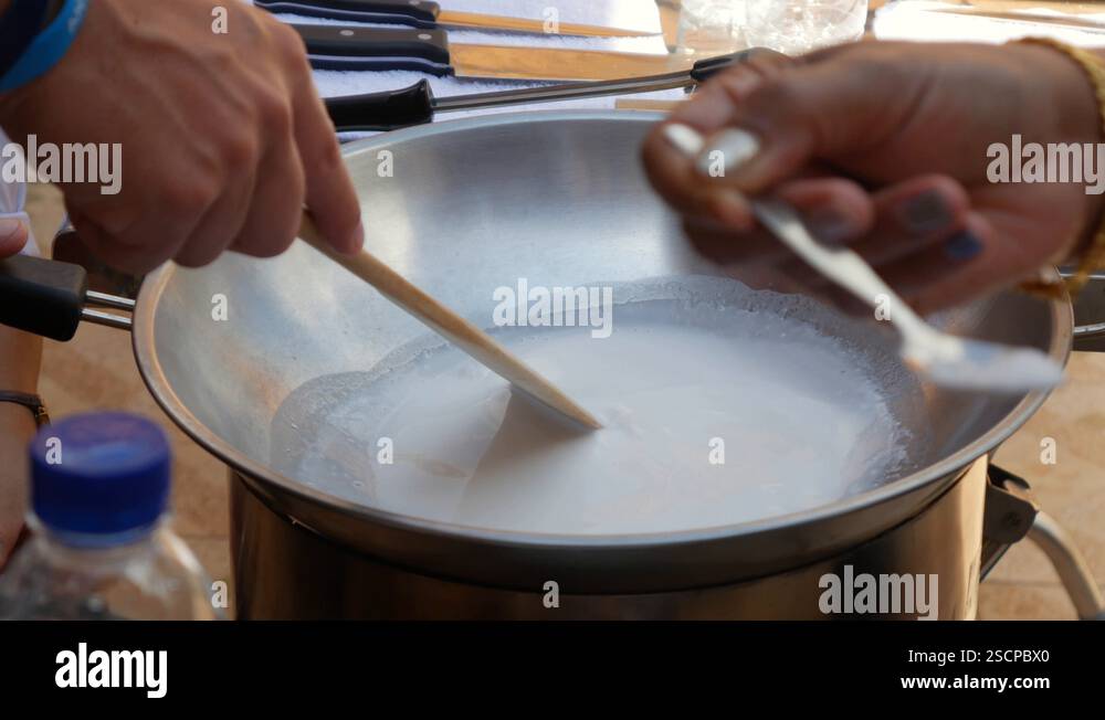 Male hand stirring boiling coconut milk in wok. Step by step cooking ...