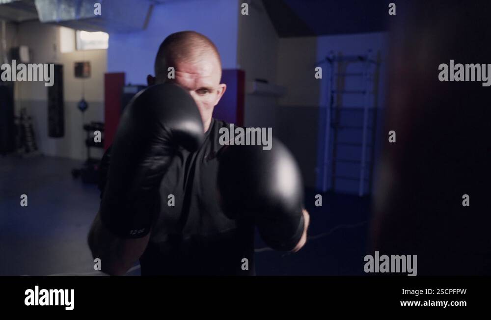 Boxer working out blows on a punching bag in slow motion, shaking ...