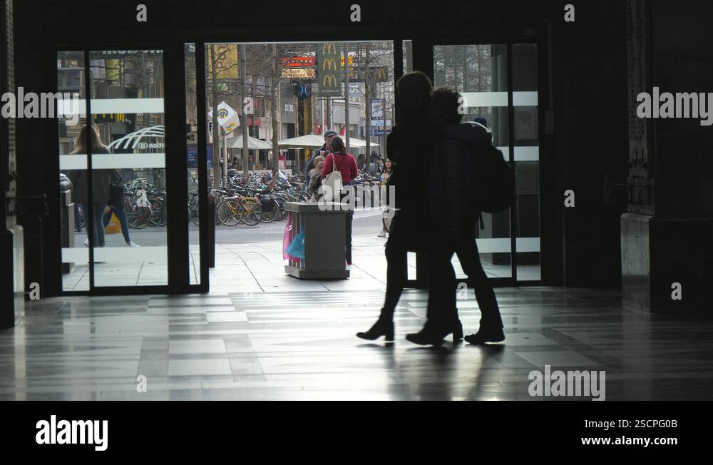 A running passenger entering the train station hall in a hurry in ...