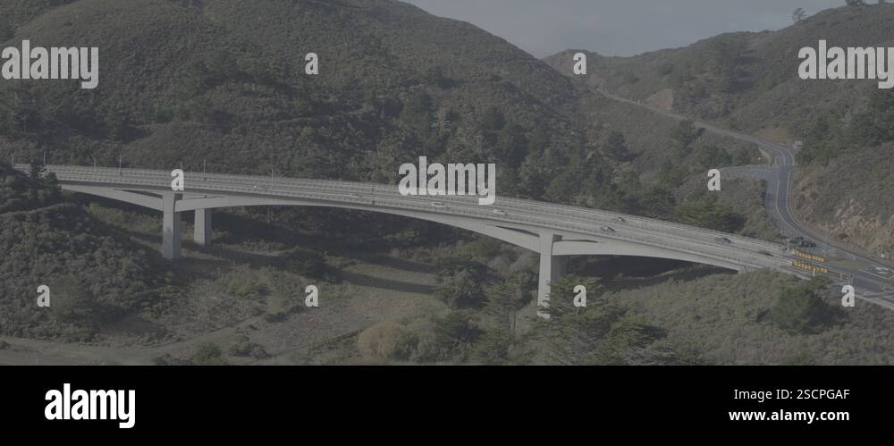 Aerial push and pan across mountain bridge to reveal tunnels Stock ...