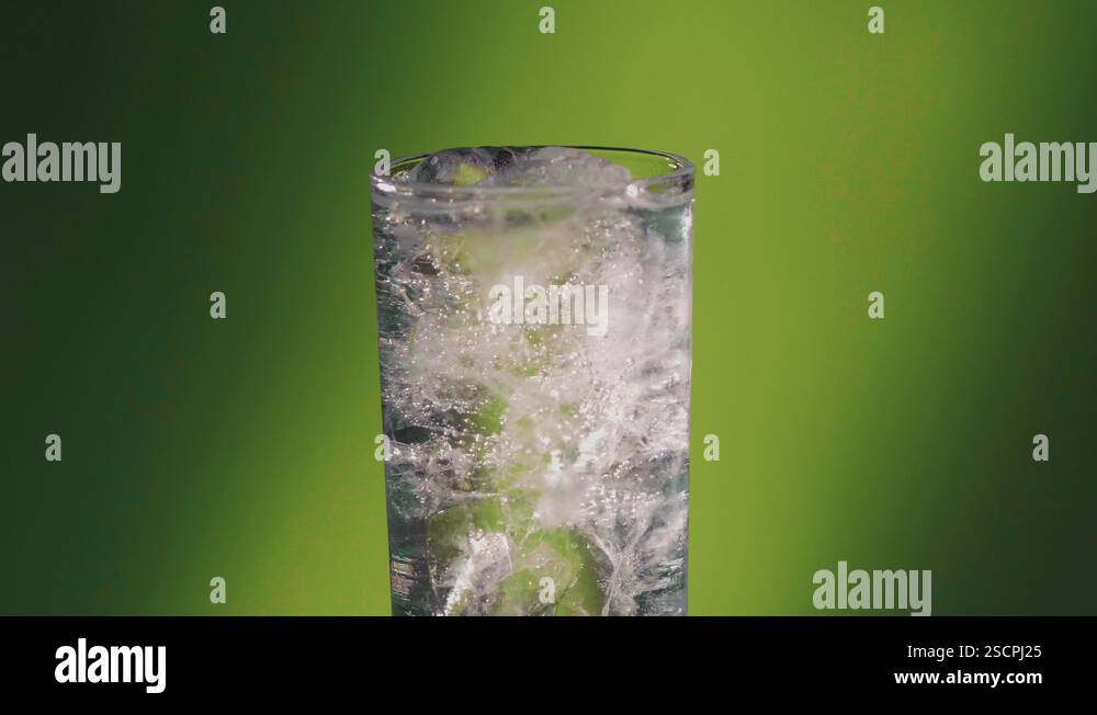 Soda water or a Sprite spinning glass, slow motion bubbles, ice cold ...