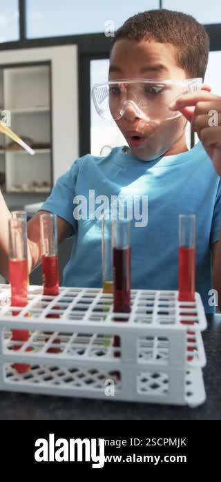Vertical video: In school, child conducting science experiment with ...