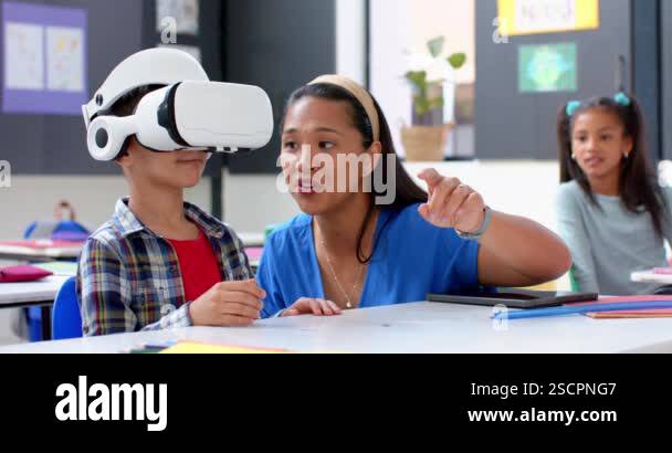 In school, teacher guiding student using VR headset in classroom ...