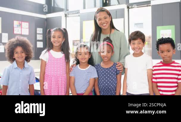 Teacher smiling with diverse group of students in classroom at school ...