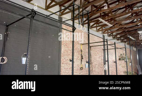 Gym equipment hanging from ceiling in a room with brick walls. Empty ...