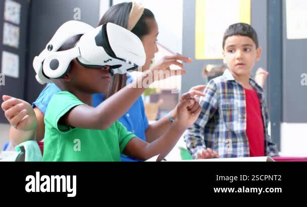 In school, boy using VR headset while teacher and classmate watching ...