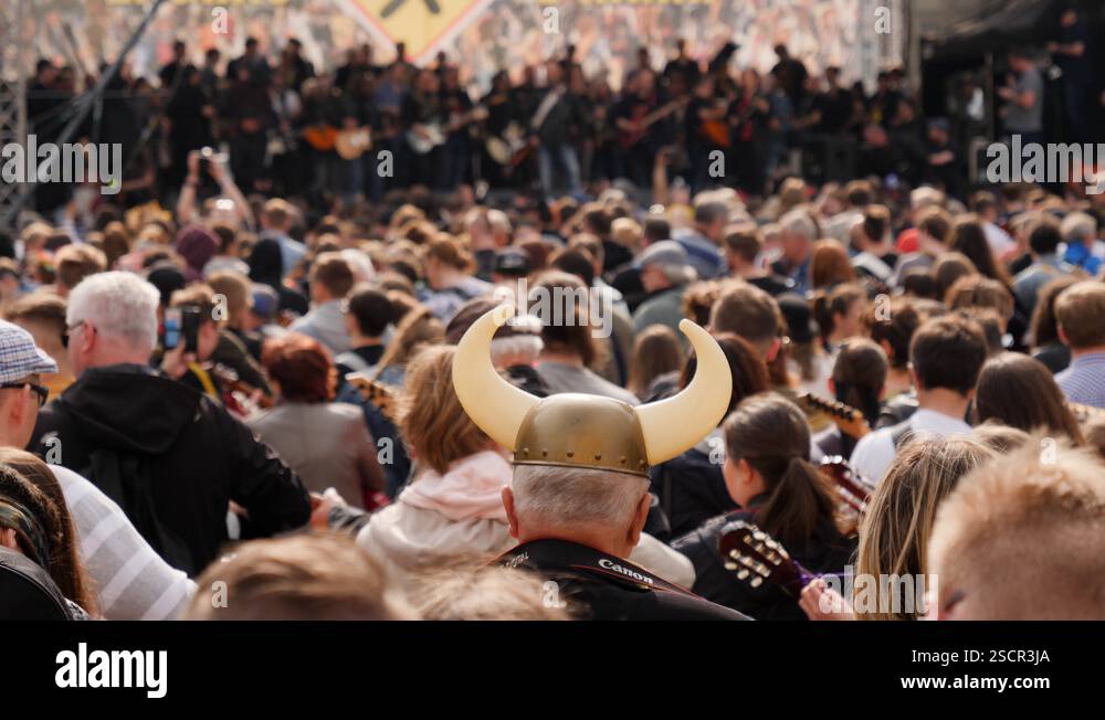 Man in viking helmet with horns stay in a concert crowd of people ...