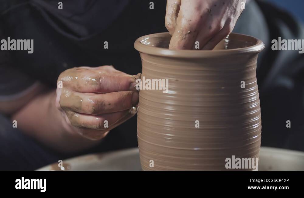 Potter creates product on potter's lathe spinning pottery in slow ...