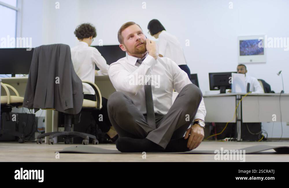 Businessman Stretching while Having Phone Call Stock Video Footage - Alamy