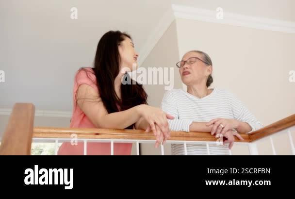 Talking and leaning on railing, Asian grandmother and granddaughter ...