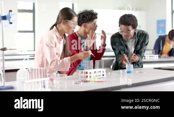 In high school laboratory, teenagers conducting chemistry experiment ...