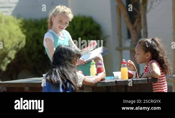 In school, three children drawing and coloring together at outdoor ...
