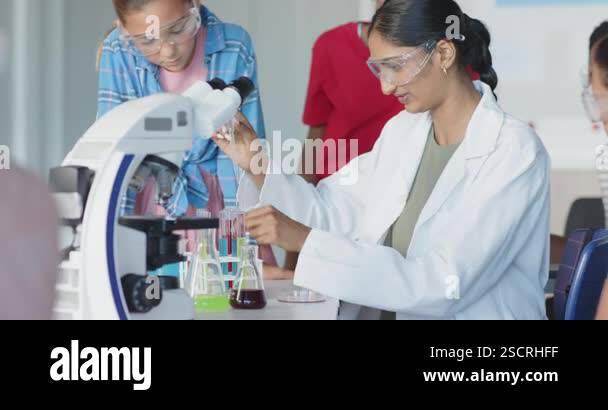 In school, students conducting science experiment with test tubes and ...