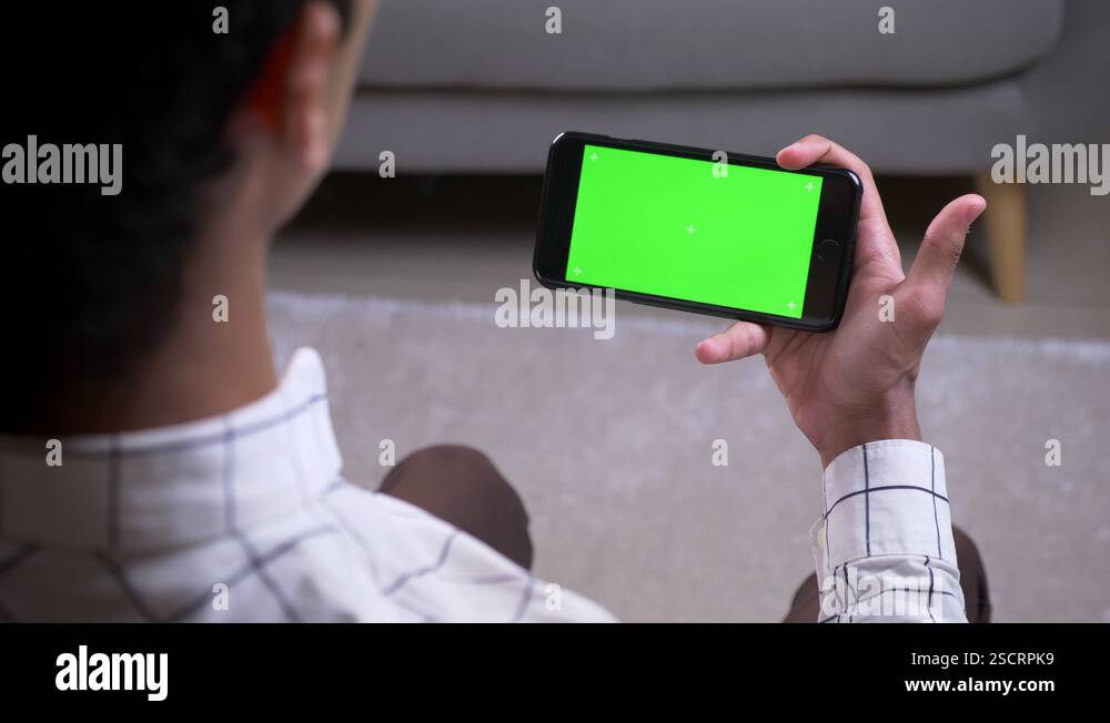 Closeup back view shoot of male having a video call with hand holding a ...
