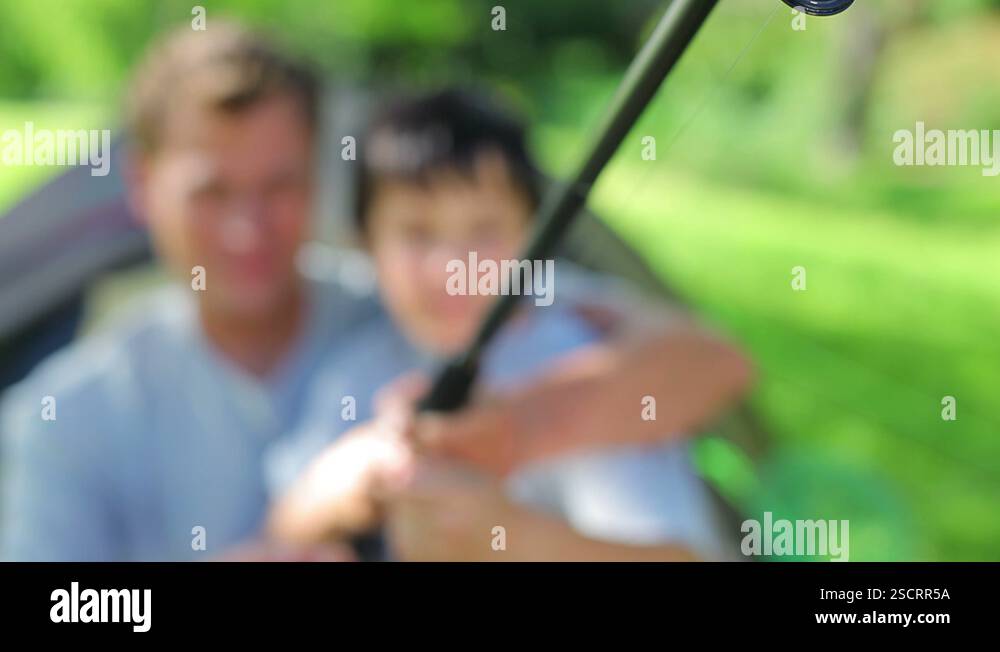 Cheerful father and son using a fishing rod Stock Video Footage - Alamy