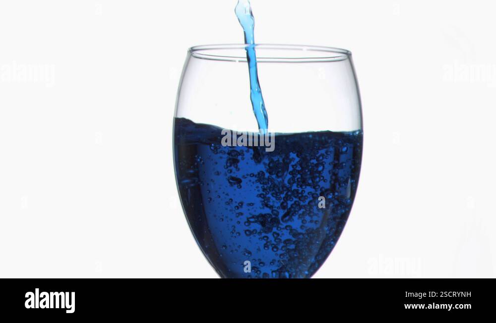 Thin blue trickle in super slow motion flowing in a full wine glass ...