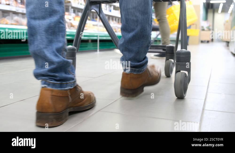 Shopping in the supermarket, view of the male legs from inside the ...