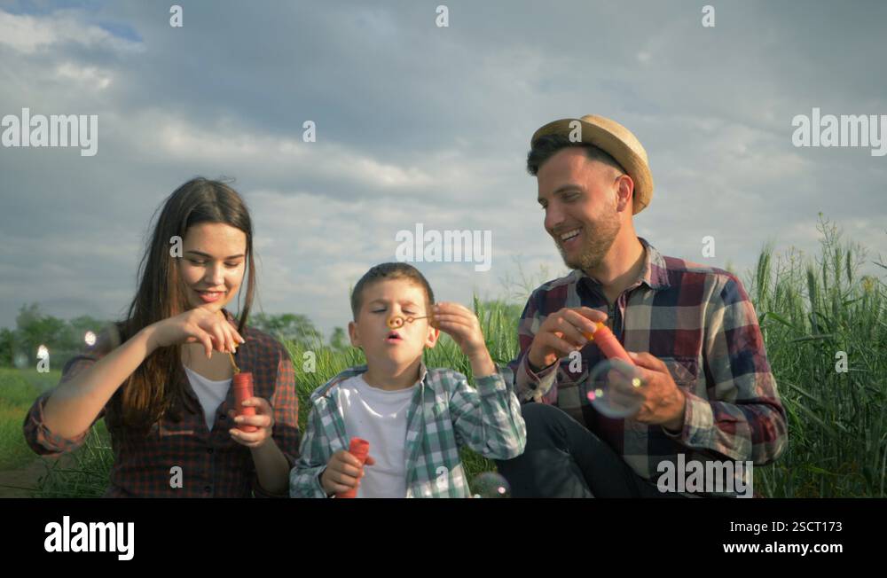family blowing soap bubbles and laughing in slow motion, little boy ...